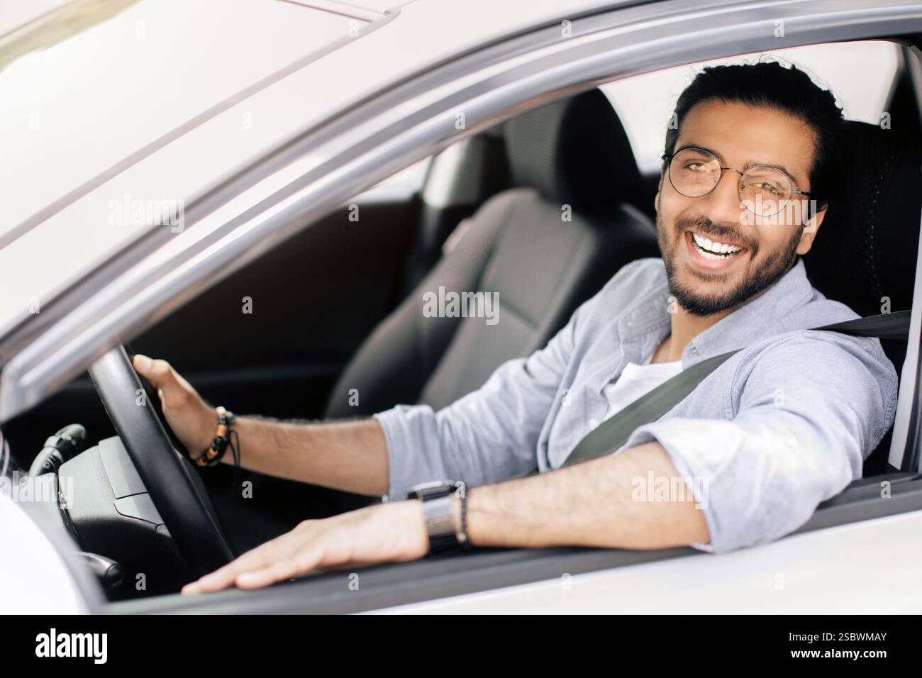 Cheerful arab guy driving right wheel car Stock Photo - Alamy