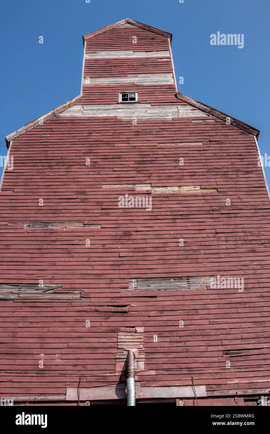 A red building with a slanted roof. The roof is made of wood. The ...