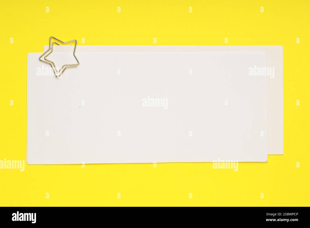 Star shaped paper clip and notes on yellow background, top view. Space ...
