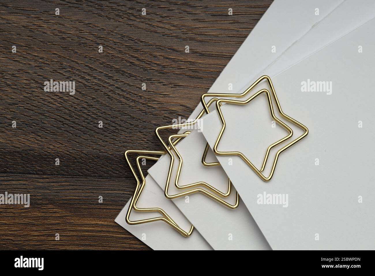 Star shaped paper clips and notes on wooden table, top view. Space for ...