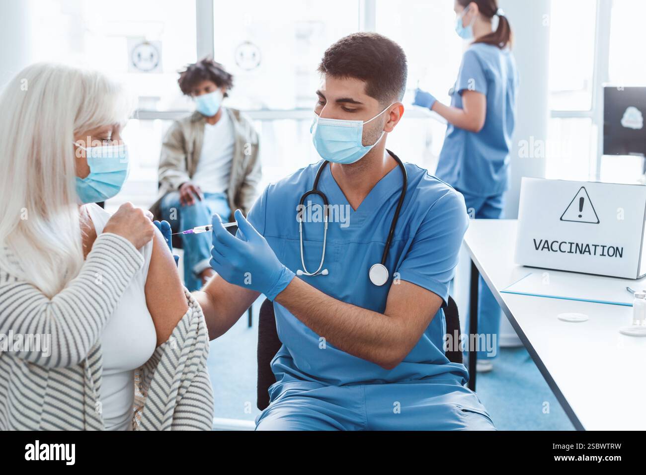 Mature Lady Receiving Vaccine Injection In Arm In Health Center Stock ...