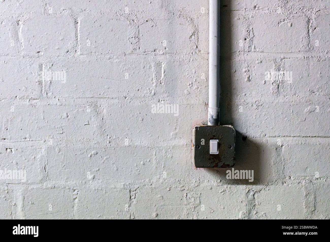 Lonely industrial light switch on white painted brick wall with texture ...
