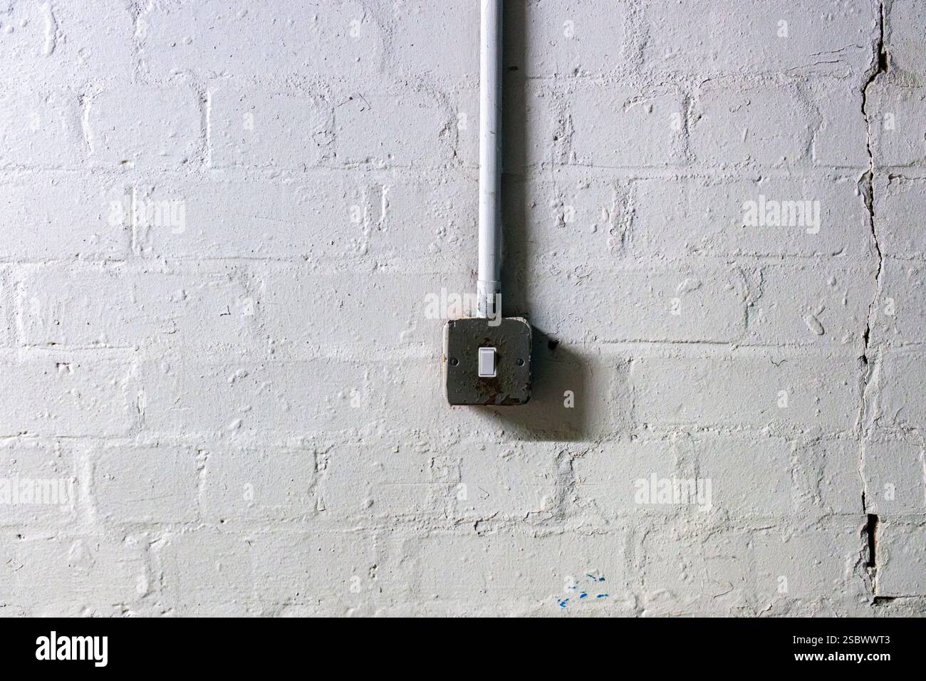 Lonely industrial light switch on white painted brick wall with texture ...