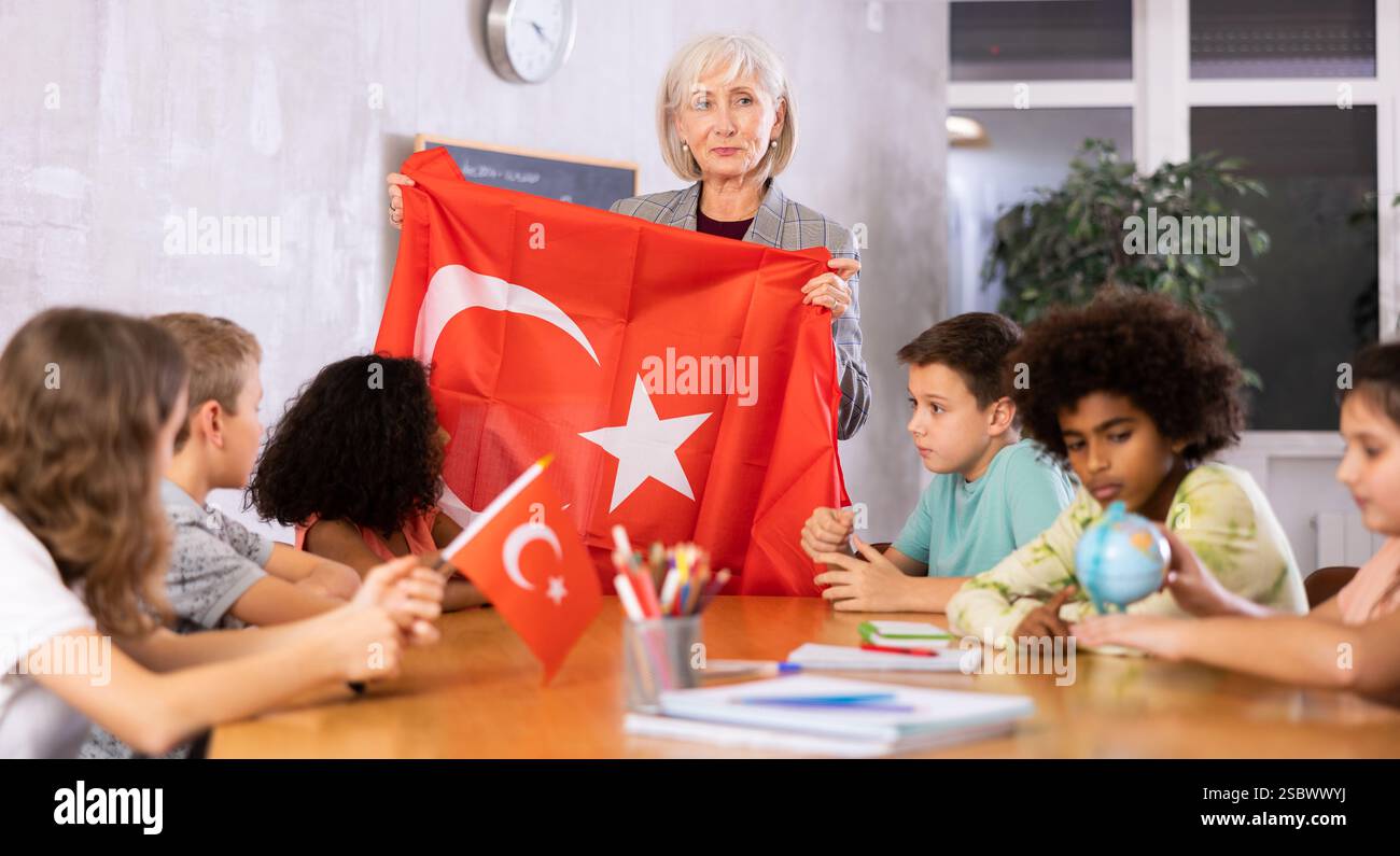 Female teacher showing turkish flag to kids in geography class Stock ...