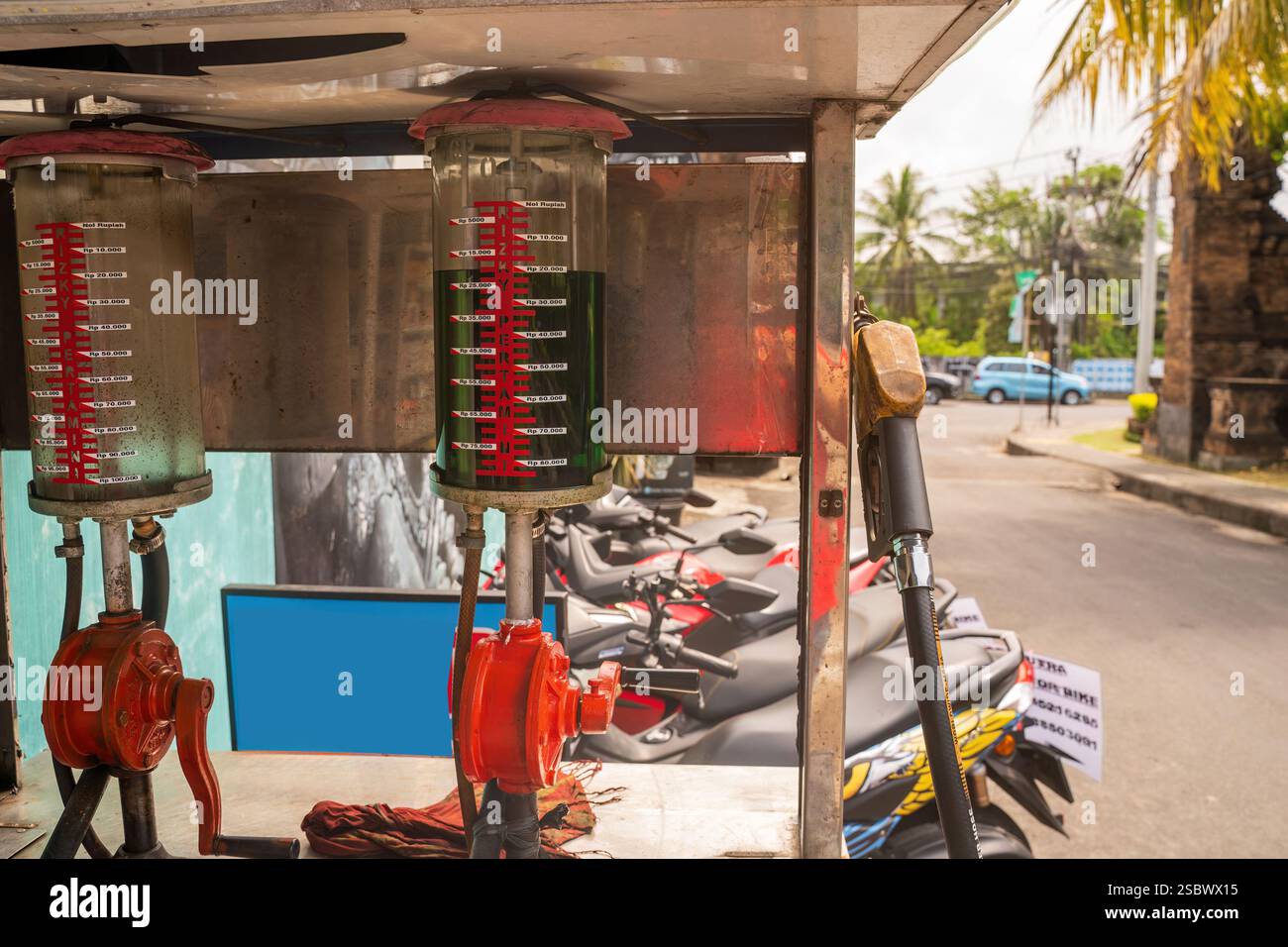 Vintage manual fuel pumps with red measurement cylinders and handles ...