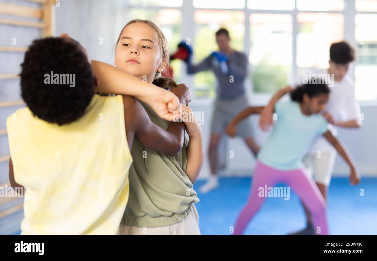Preteen children pairs learning strength self-defense in gym Stock ...