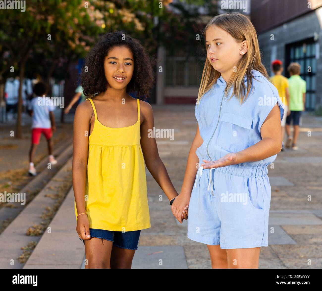 Two girls talking during walk Stock Photo - Alamy