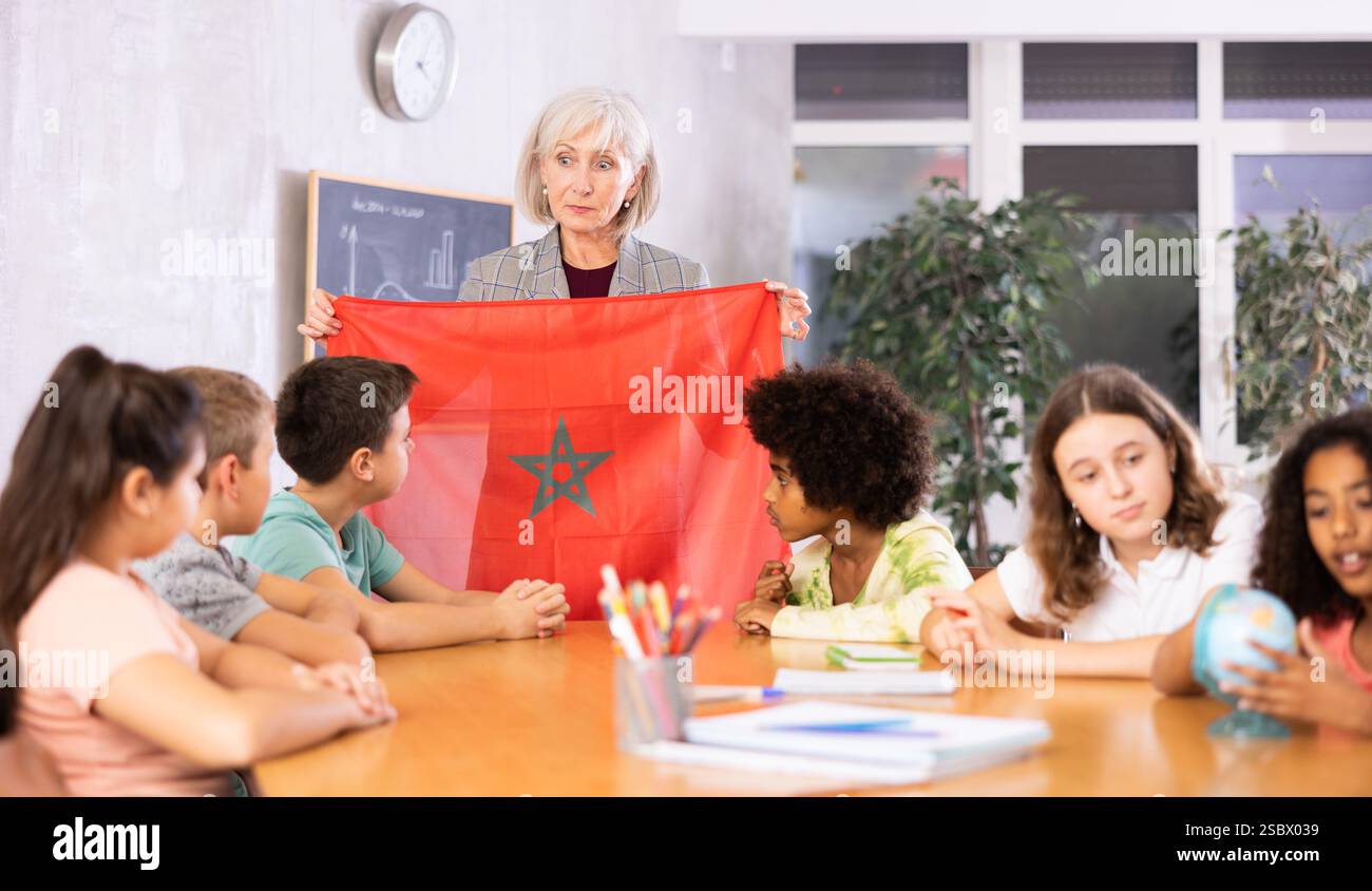 Female teacher showing moroccan flag to kids in geography class Stock ...