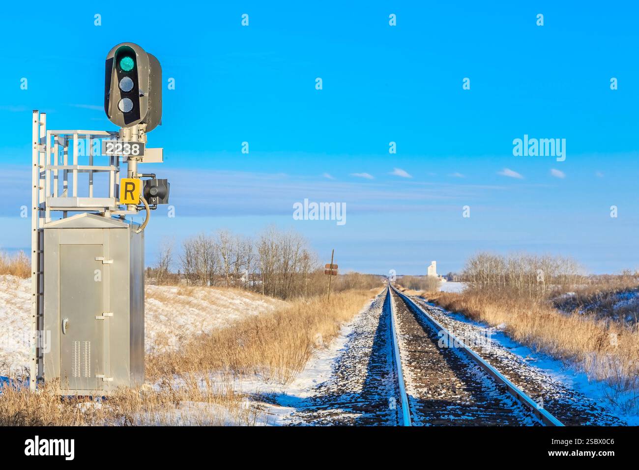 Railroad crossing sign is on a pole. The sign is green and says "R ...