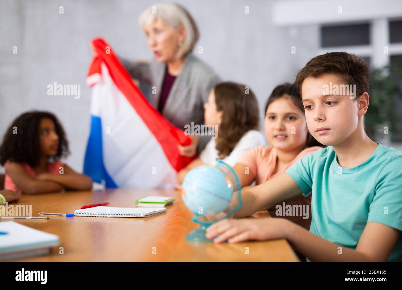 Female teacher showing dutch flag to kids in geography class Stock ...