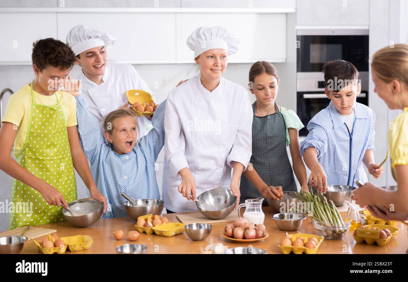 Two friendly chefs giving culinary lesson to group of tweens Stock ...