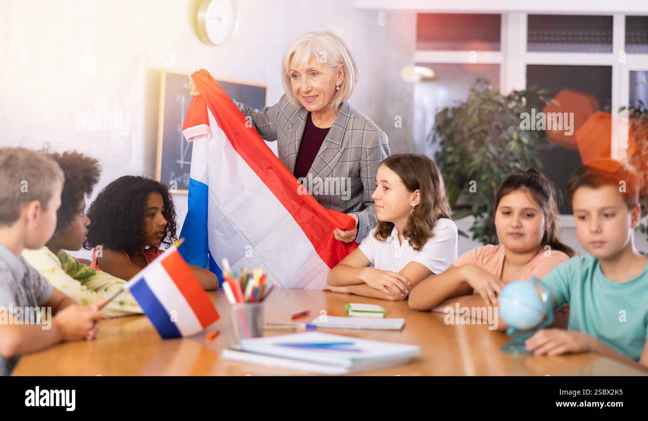 Female teacher showing dutch flag to kids in geography class Stock ...