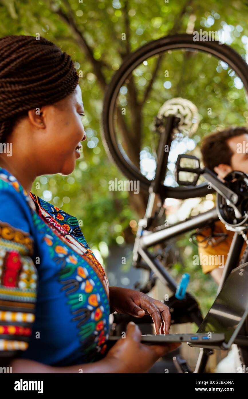 Healthy and vibrant african american fermale researching on internet for bicycle gear maintenace ...