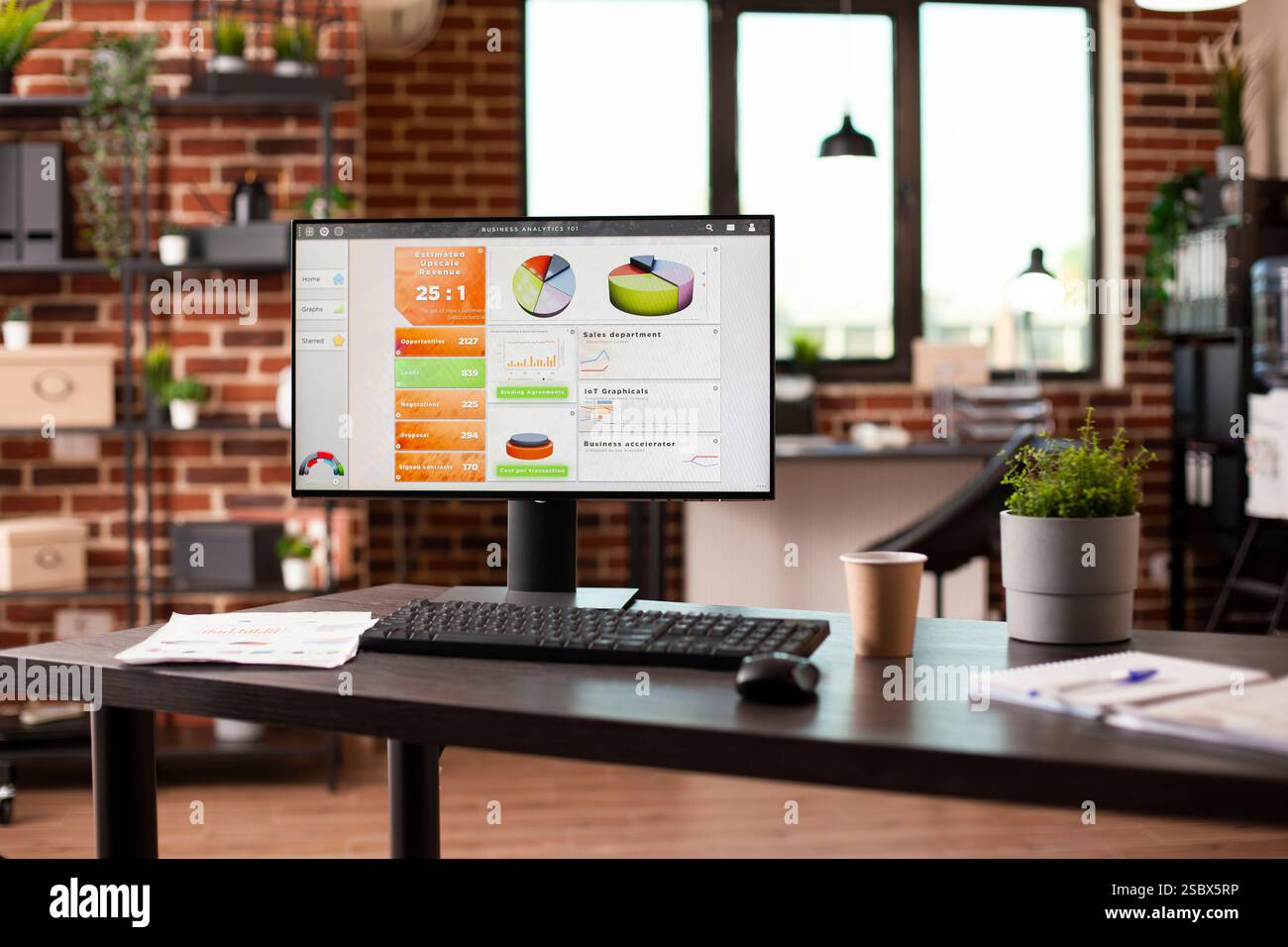 Vacant brick wall workspace with desktop monitor, notebooks and ...