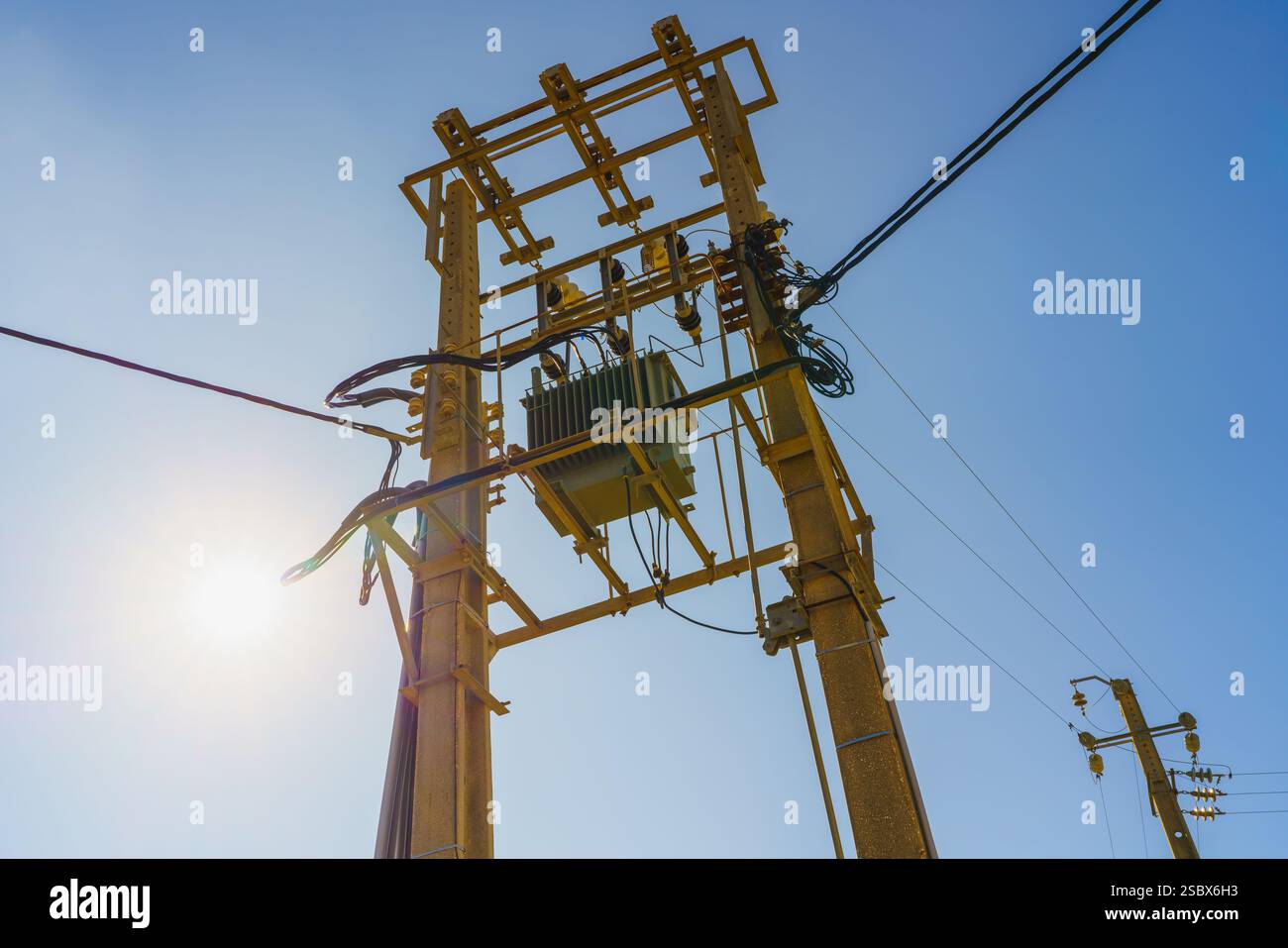 Electrical power transformer mounted on a utility pole with wires ...