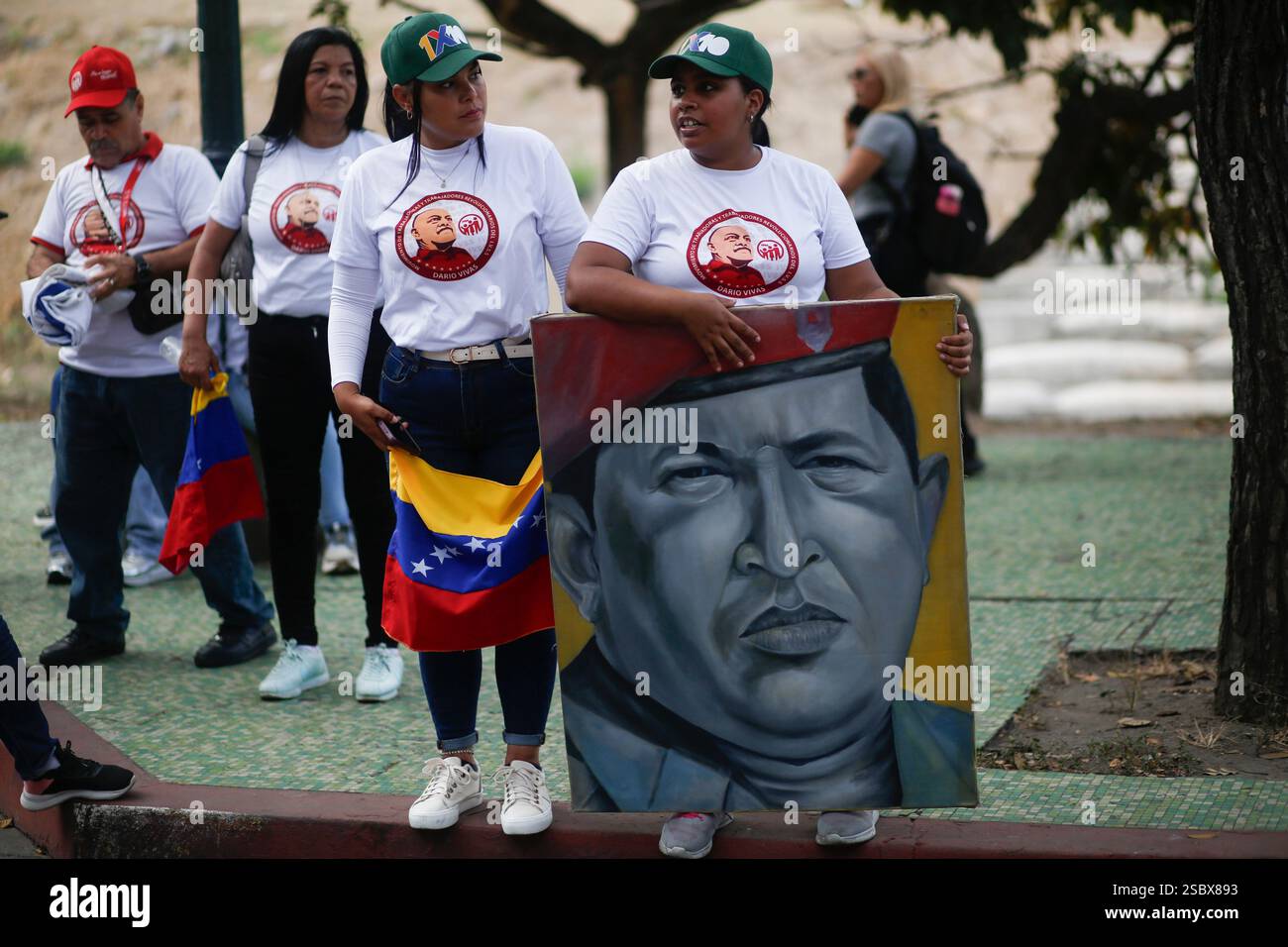 A government supporter holds a painting depicting the late Venezuelan ...