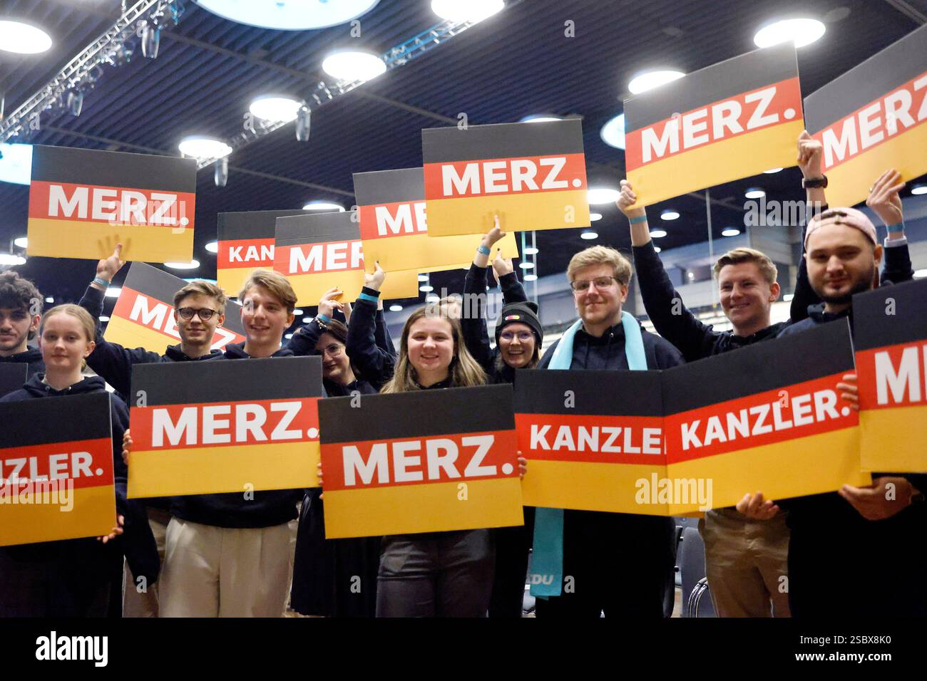 CDU-Mitglieder halten Plakate im Stil von Deutschlandfahnen hoch, auf ...