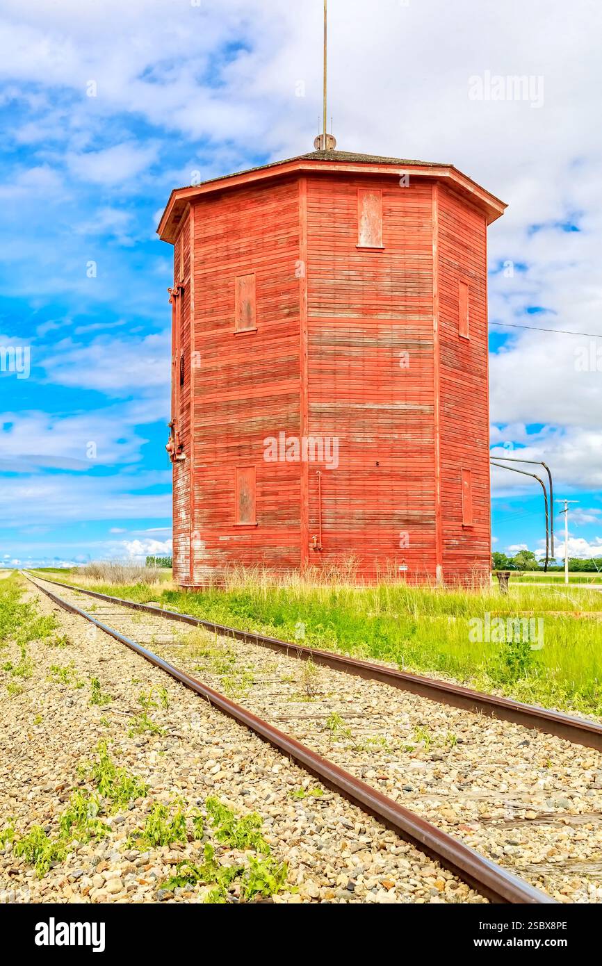 Red tower is on the side of a railroad track. The tower is surrounded ...