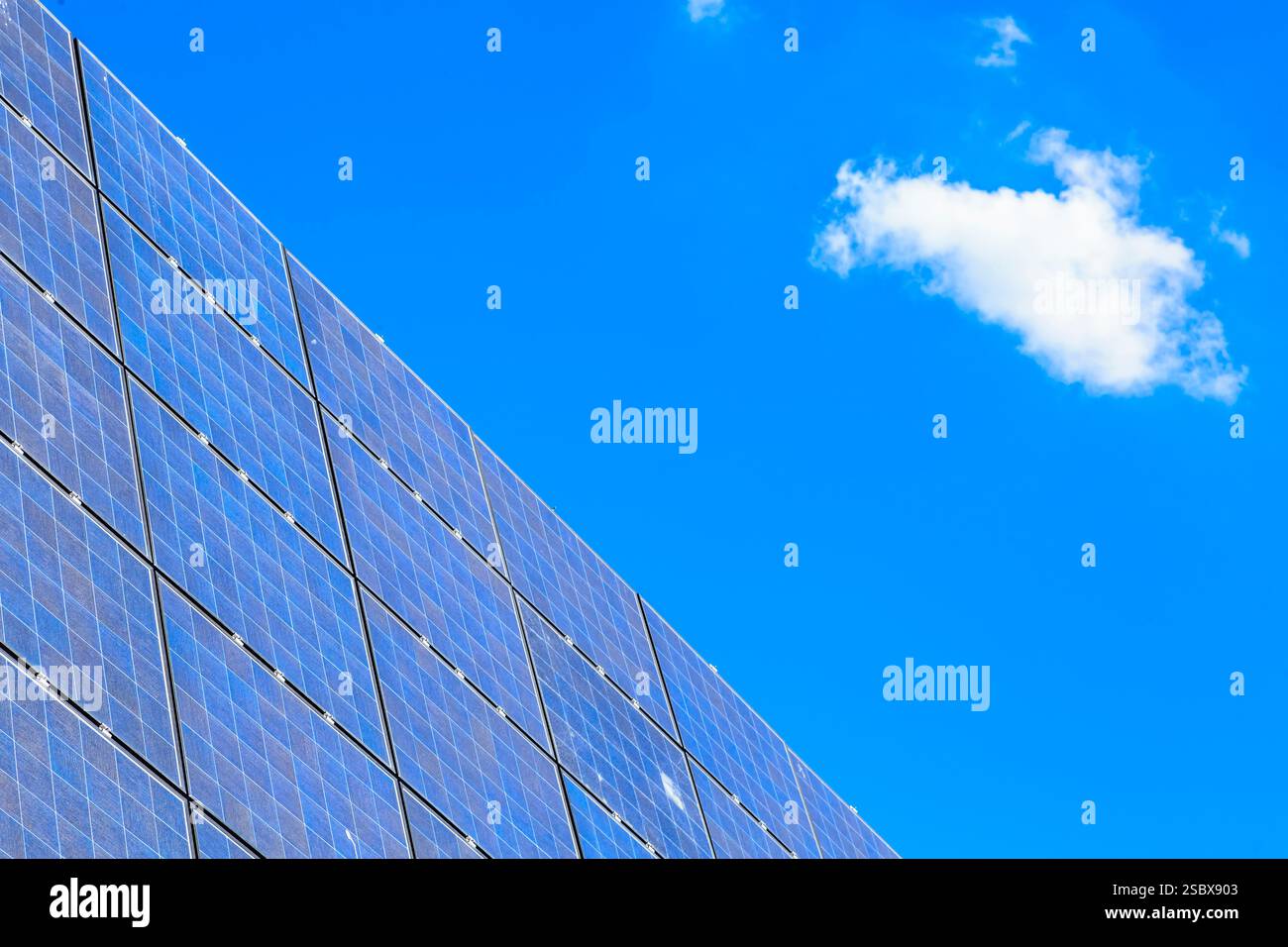 Solar panel is on a building. The sky is blue and there is a cloud in ...