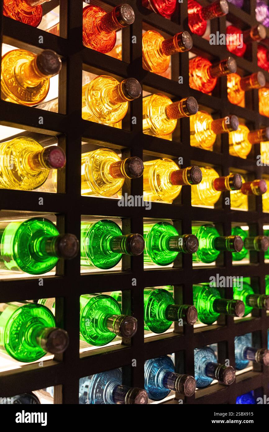 Colorful liquor bottles in a gridded display. Many different colors ...
