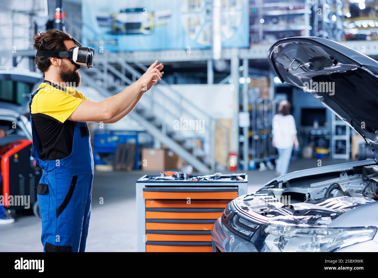 Mechanic in auto repair shop using virtual reality goggles to visualize ...