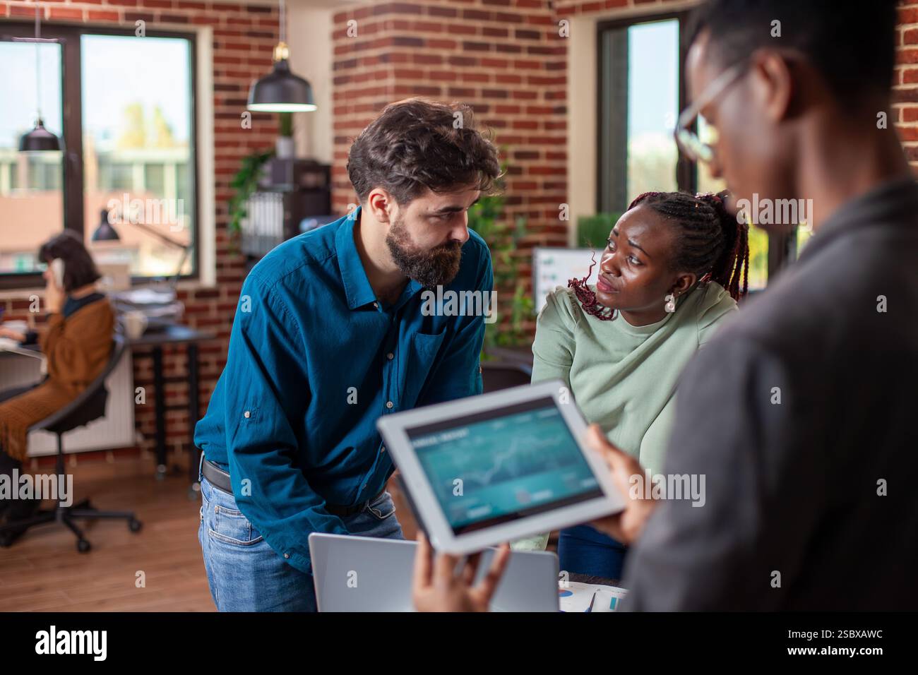 Black woman collaborates with colleague on laptop as male analyst ...