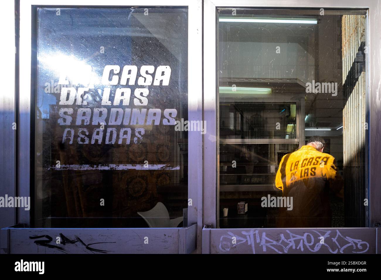 Modern bar façade featuring handwritten signage with a back alley light ...