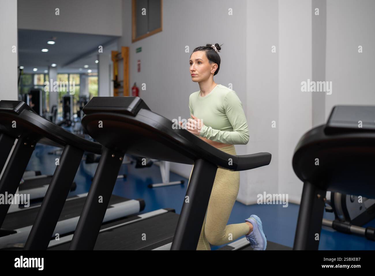 Dedicated athlete running intensely on treadmill, enhancing ...
