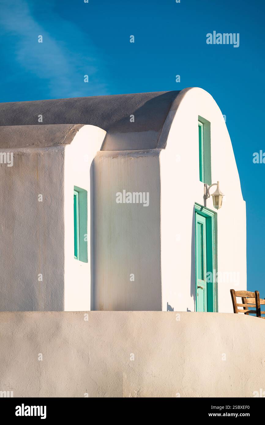 Cuboid white house with barrel-shaped roof and green windows in golden ...