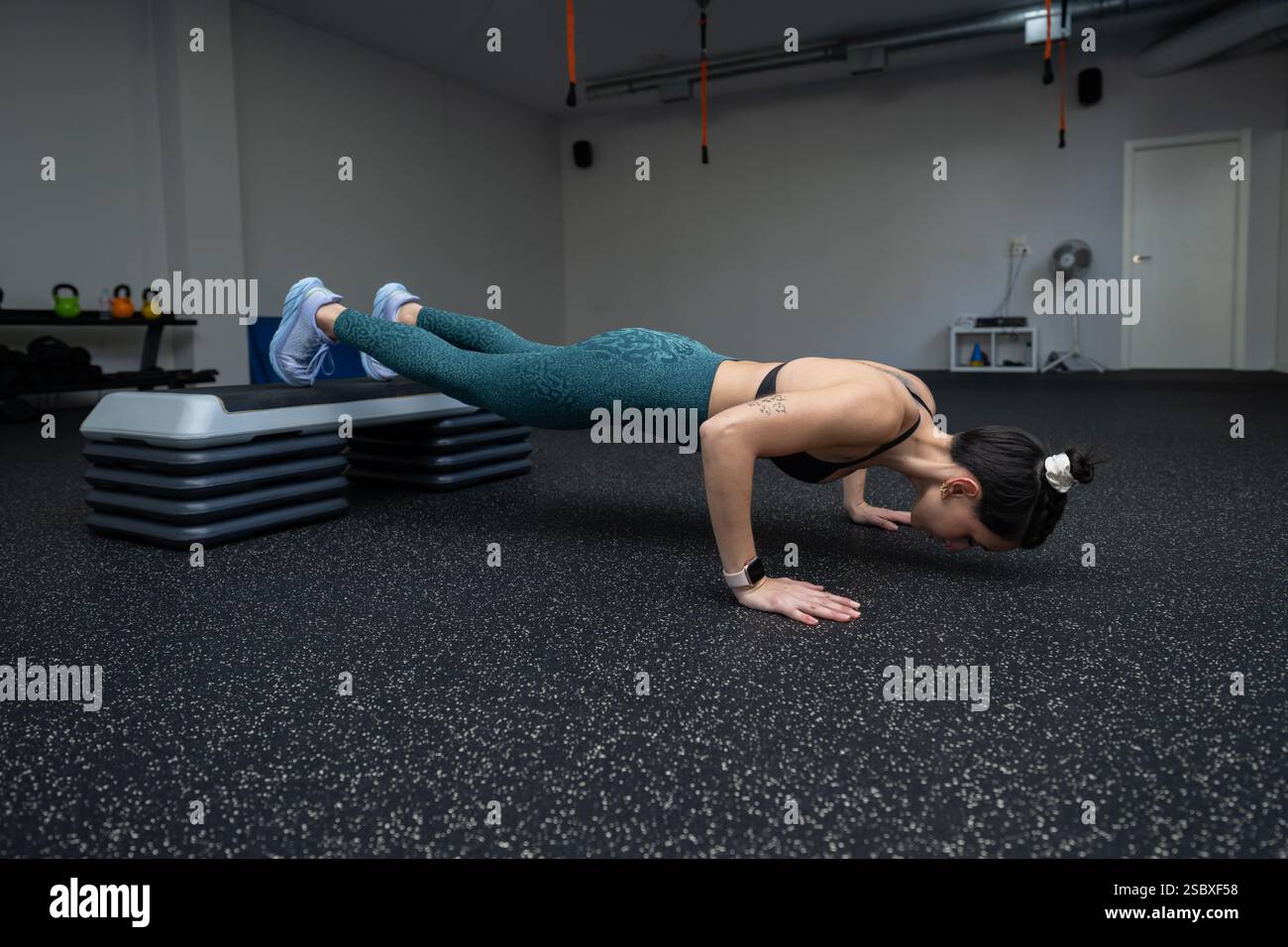 Athletic woman doing elevated push ups, targeting core strength while ...