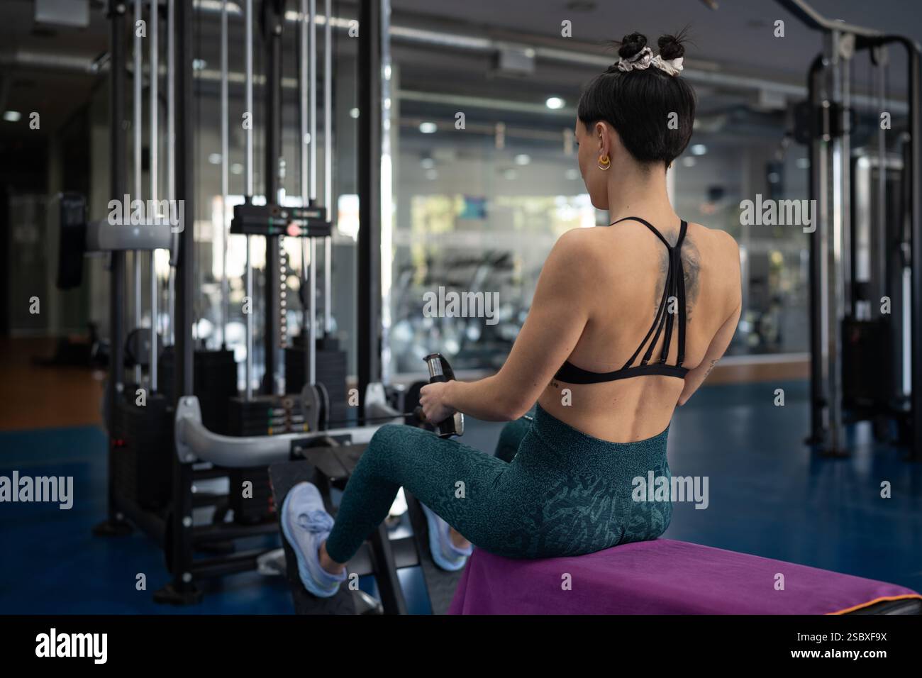Female athlete executing seated cable row exercise, targeting back muscles in contemporary ...