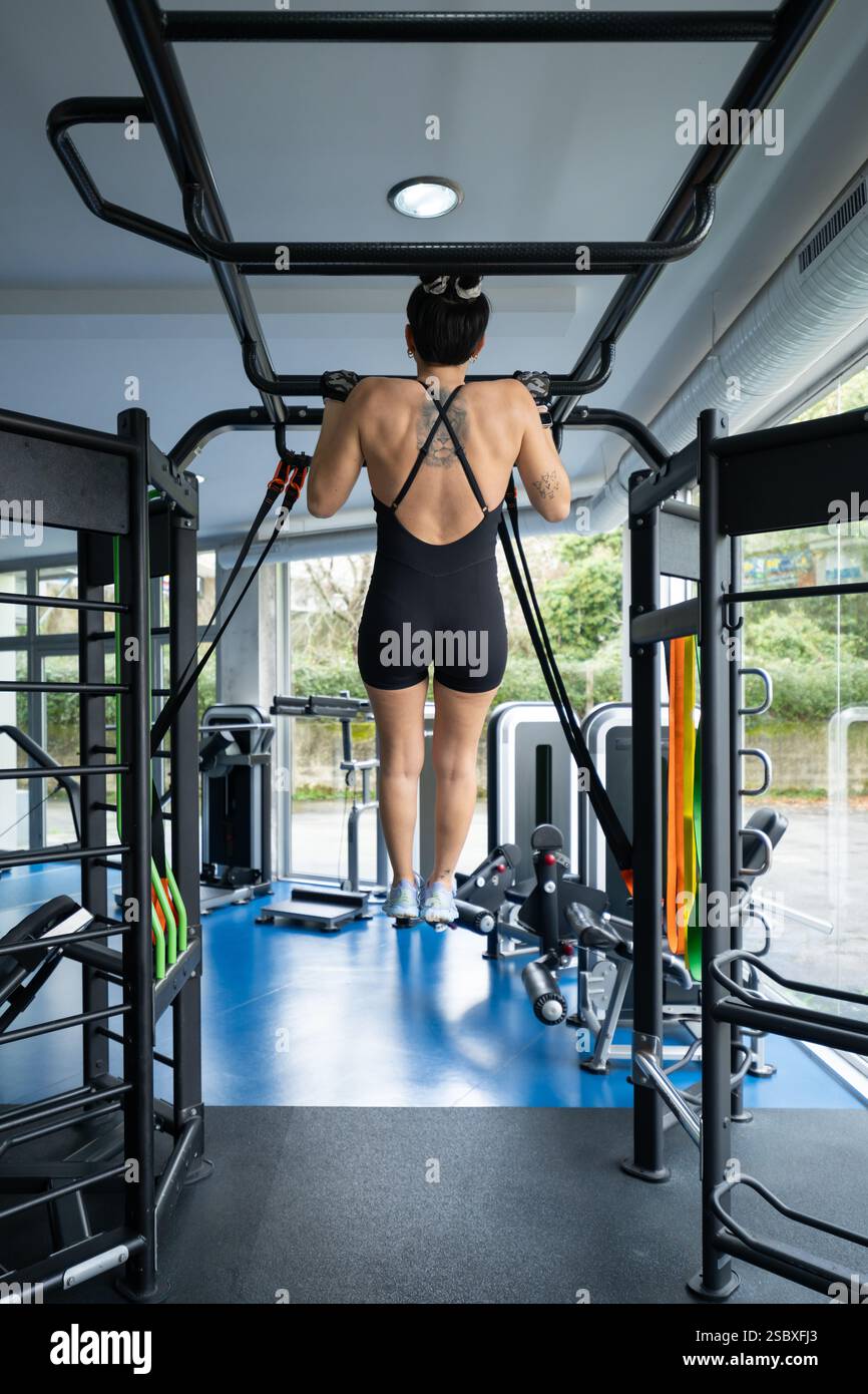 Strong female athlete exercising on pull up bar, demonstrating strength ...