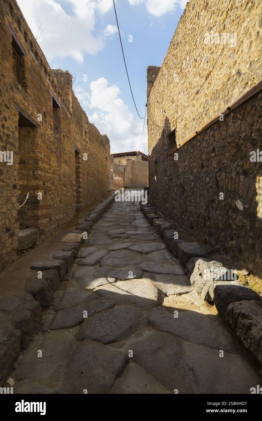 Long narrow street made of large grey smooth and worn lava stones with ...