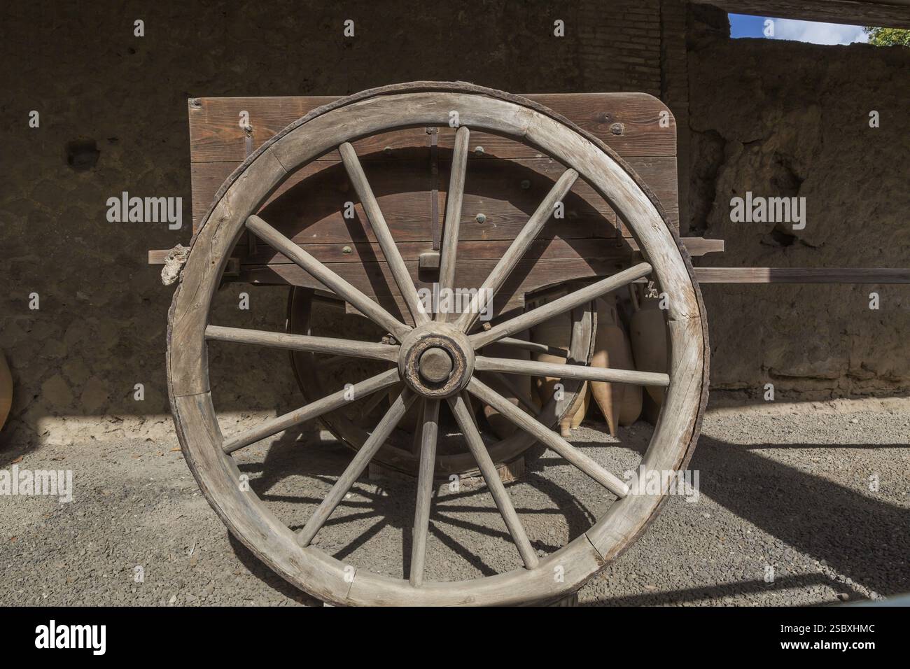 Old wooden cart and ceramic jugs on display inside an unenclosed ...
