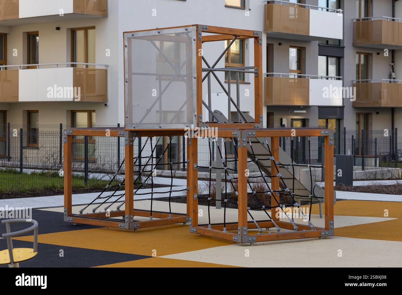 Modern wooden playground with climbing nets and a slide in a ...