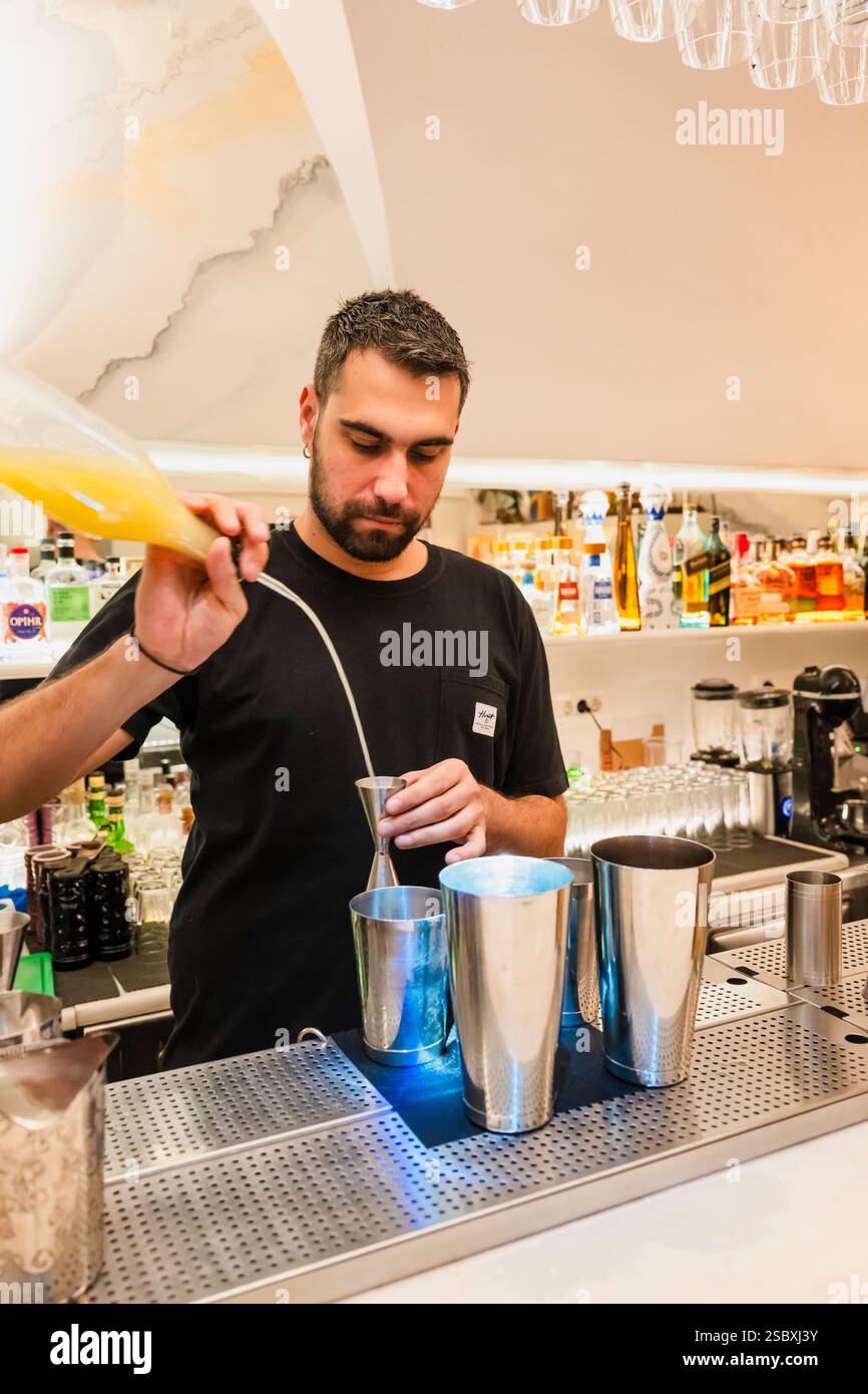 A Greek barkeeper mixes a drink at the counter of the Hassapiko Bar in ...