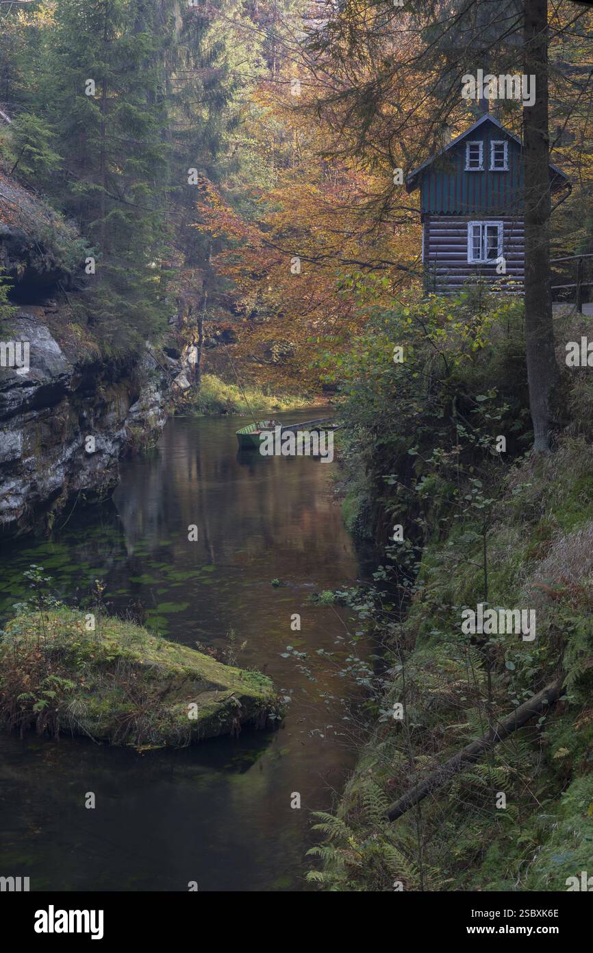 Log house and flowing water with ferns and rocks in the Edmunds Gorge ...