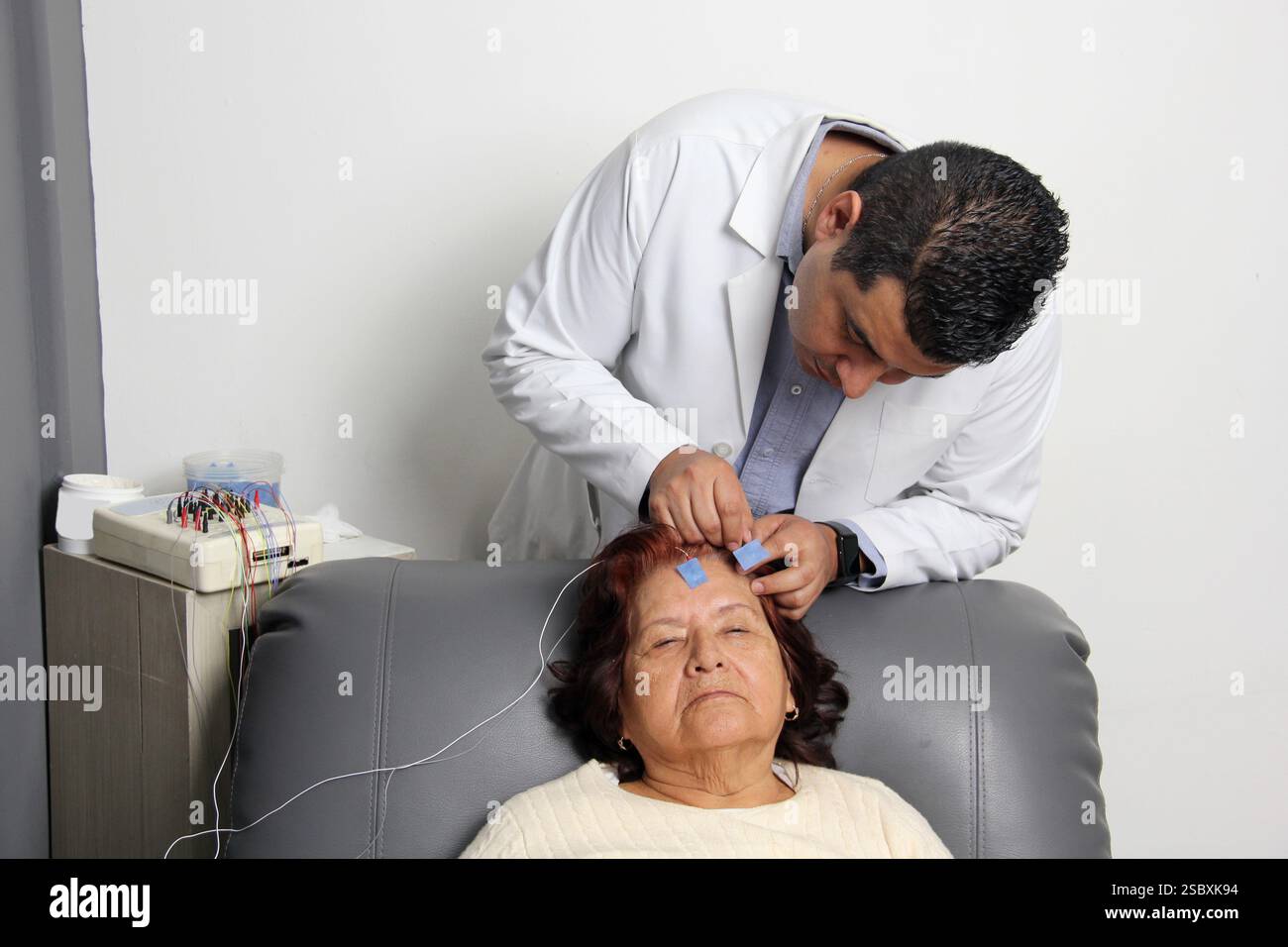 Elderly Latin woman undergoes EEG electroencephalogram to detect dementia or Alzheimer's disease ...