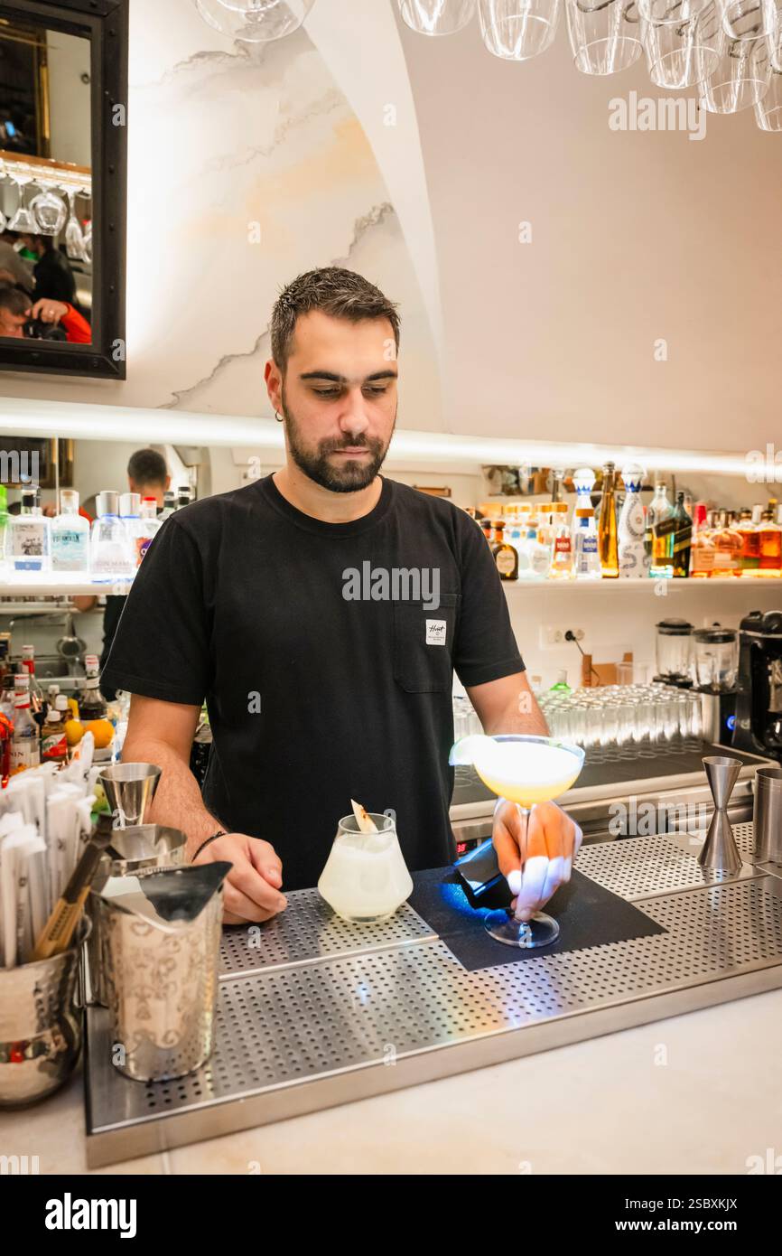 A Greek barkeeper mixes a drink at the counter of the Hassapiko Bar in ...