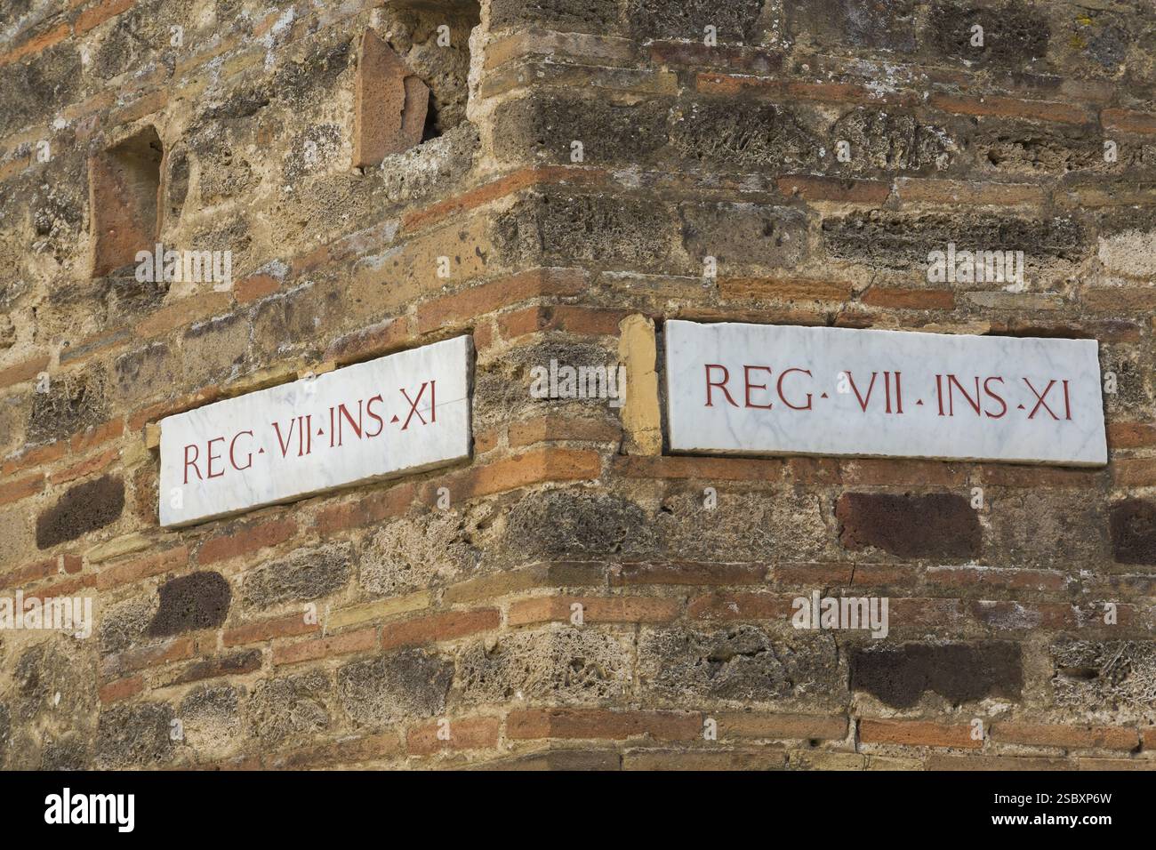Street names inscribed on white marble plaques on terracotta brick and ...
