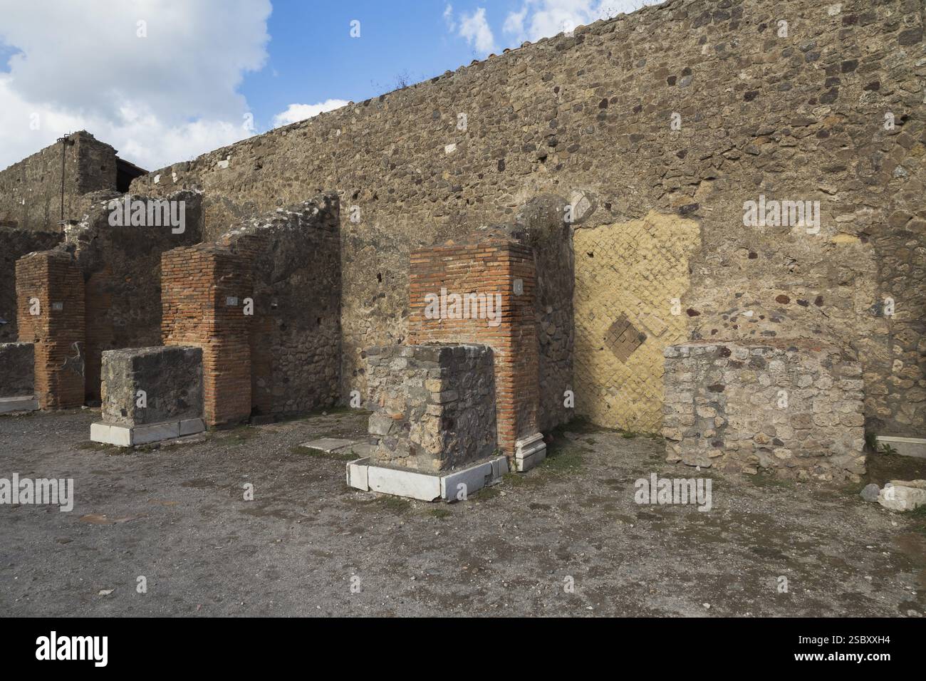 Remnants of old terracotta brick and stone wall structure plus numbered ...