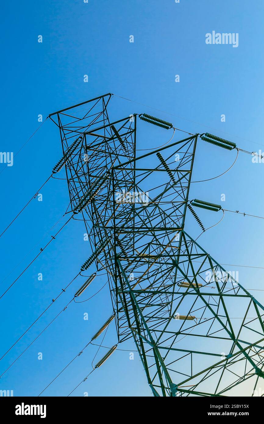 Tall power tower with wires and a blue sky in the background. The tower ...