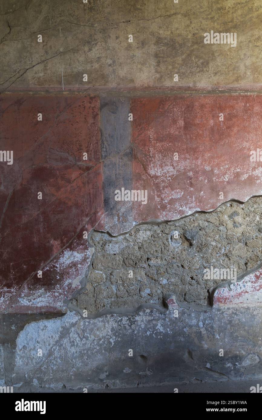Close-up of damaged plaster wall with reddish brown fresco and stone ...