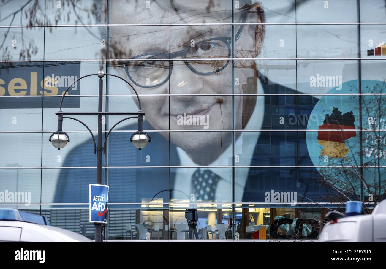 An AfD poster hangs in front of the portrait of CDU chancellor ...