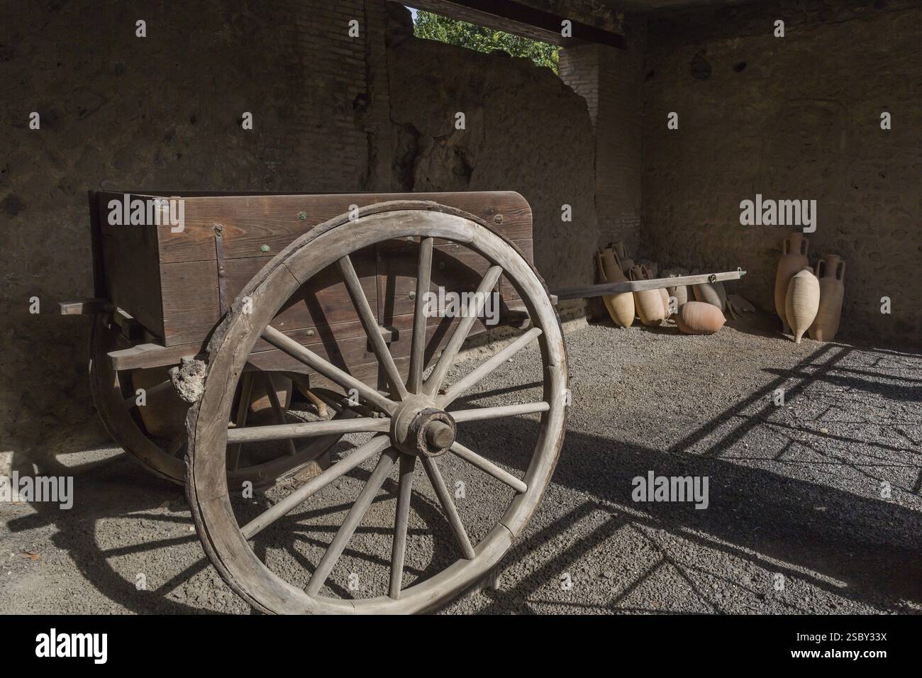 Old wooden cart and ceramic jugs on display inside an unenclosed ...