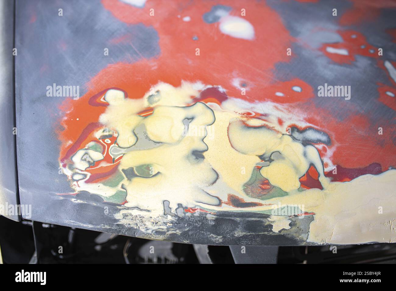 Surface with red and cream paint patches creating an abstract texture ...