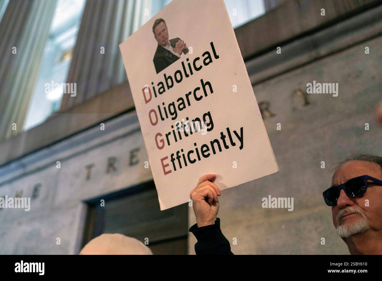 People protest during a rally against Elon Musk outside the Treasury ...