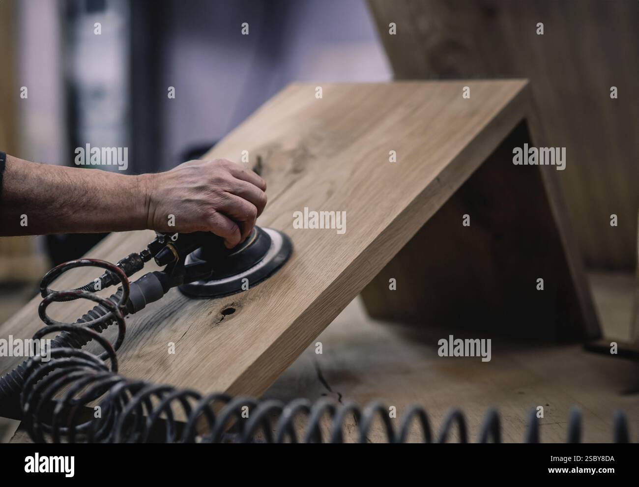 A hand crafting wood with a sanding tool, emphasizing precision and ...