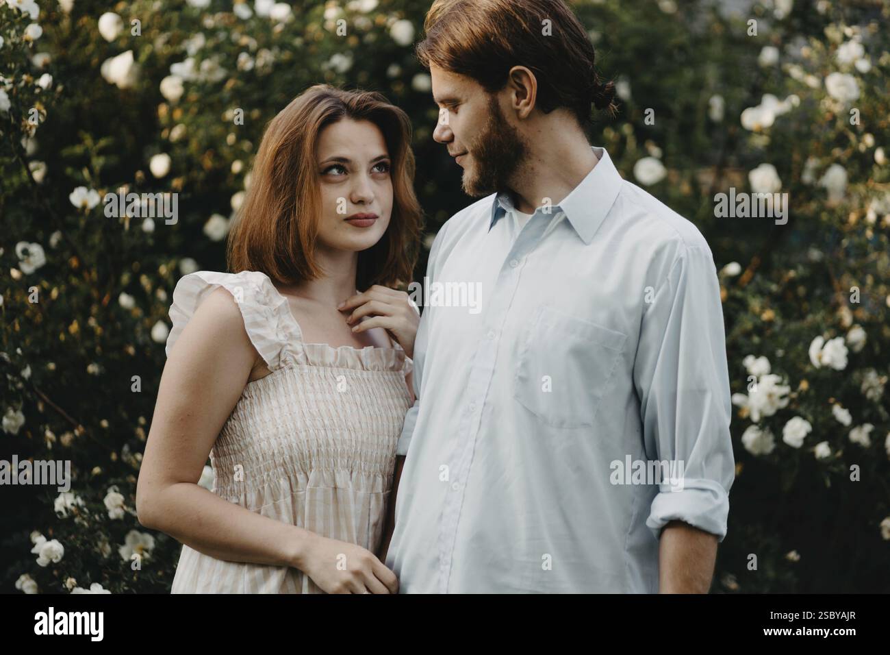 A couple sharing a deep connection, standing together in a garden ...