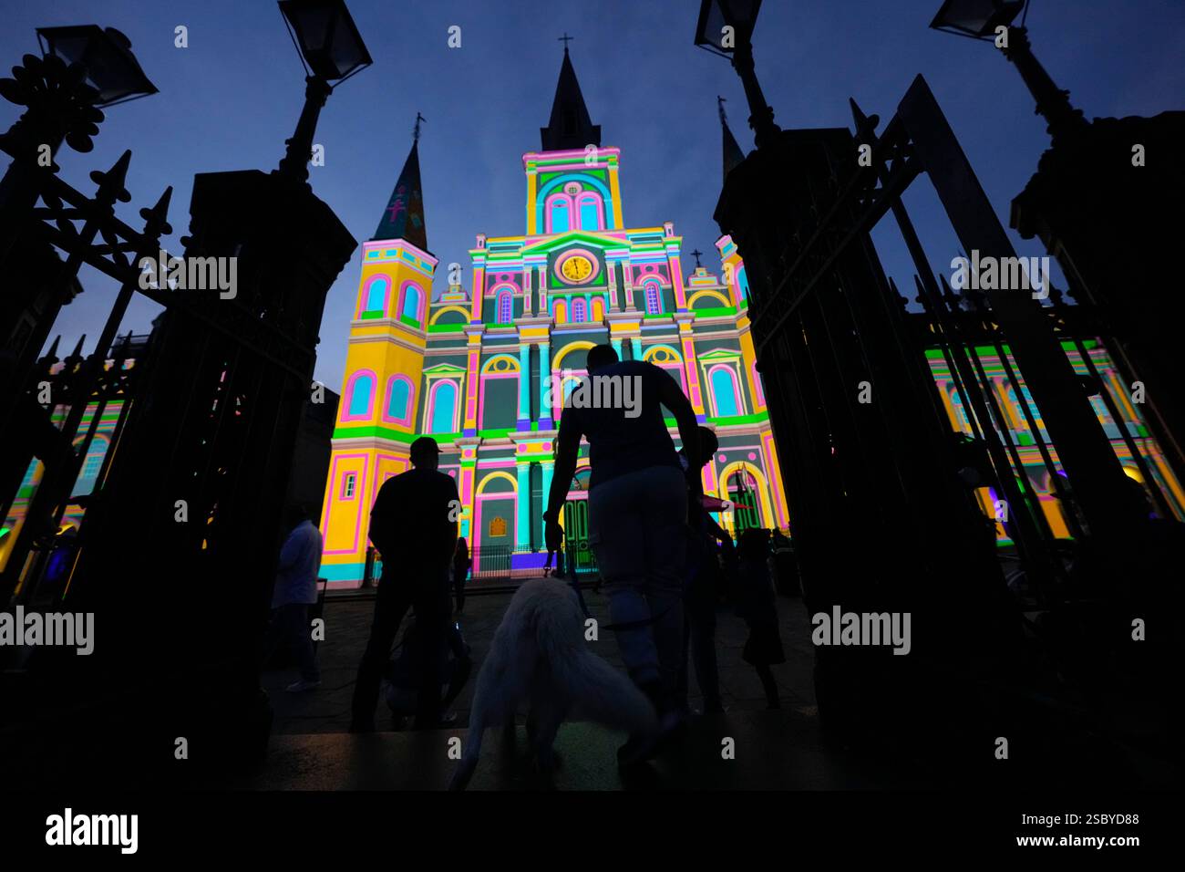 People watch a laser light show projected onto St. Louis Cathedral in ...